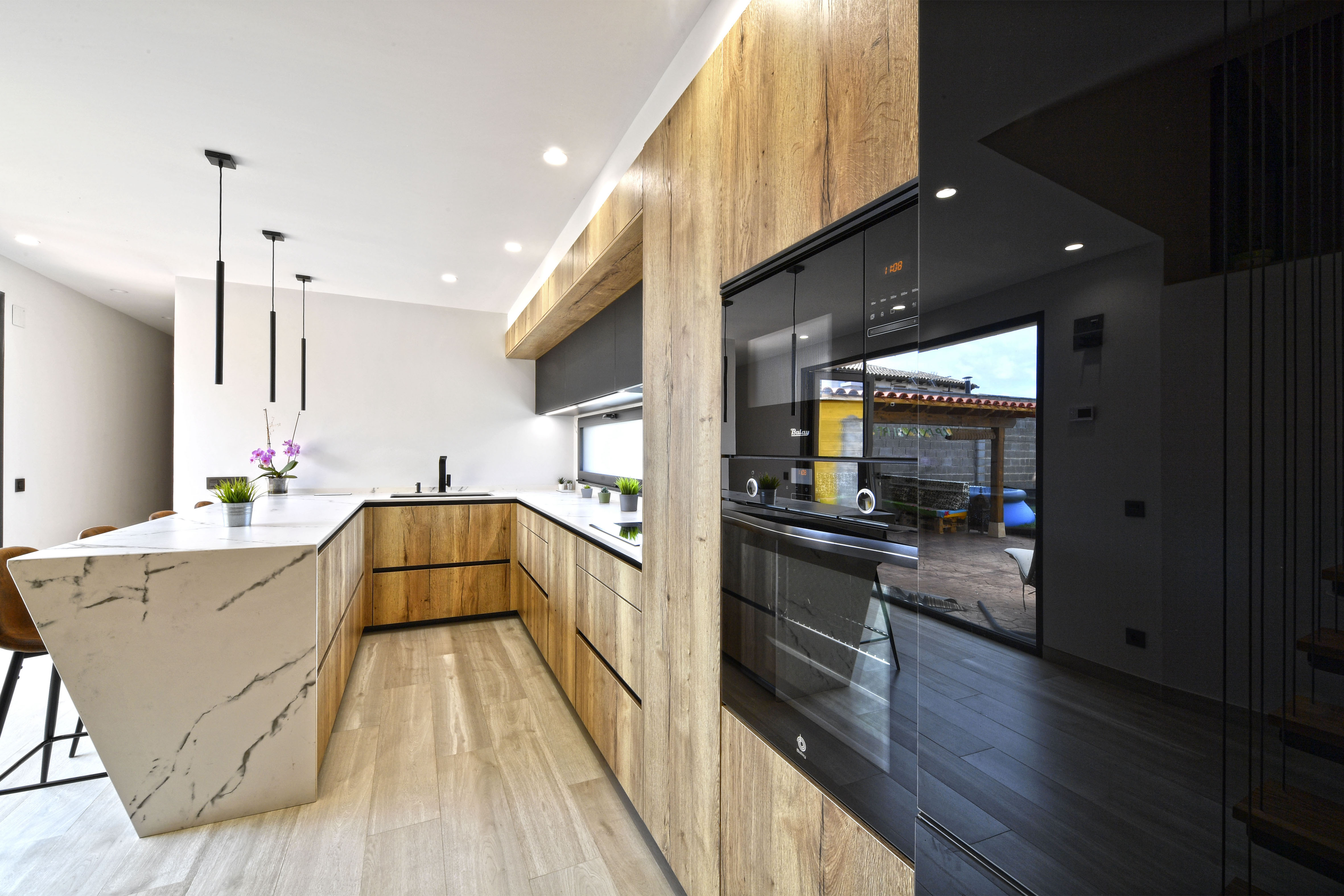 Cocina moderna en U con peninsula madera y Dekton - CJR